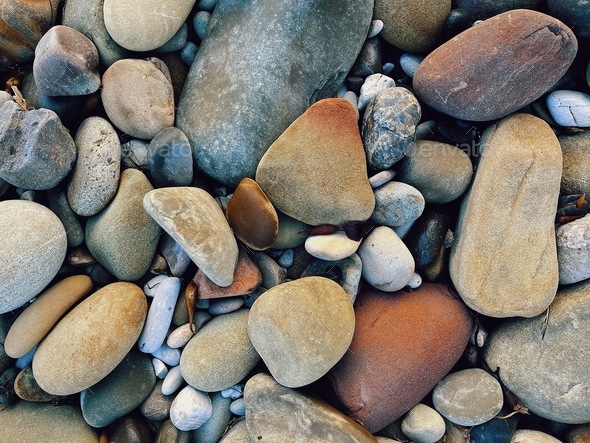 Background of textured colored rocks and pebbles on a rocky beach in ...