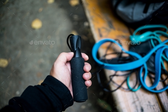 Hand of young man holding Skipping rope or jump rope outside and ...
