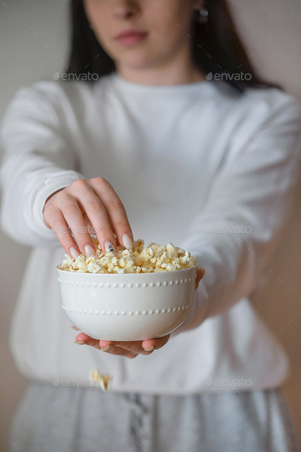 Making popcorn at home, teen girl in white holds out popcorn Stock ...