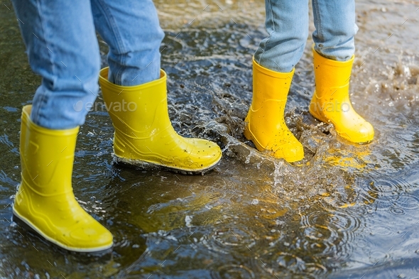two children on an active and fun walk through the puddles in the warm ...