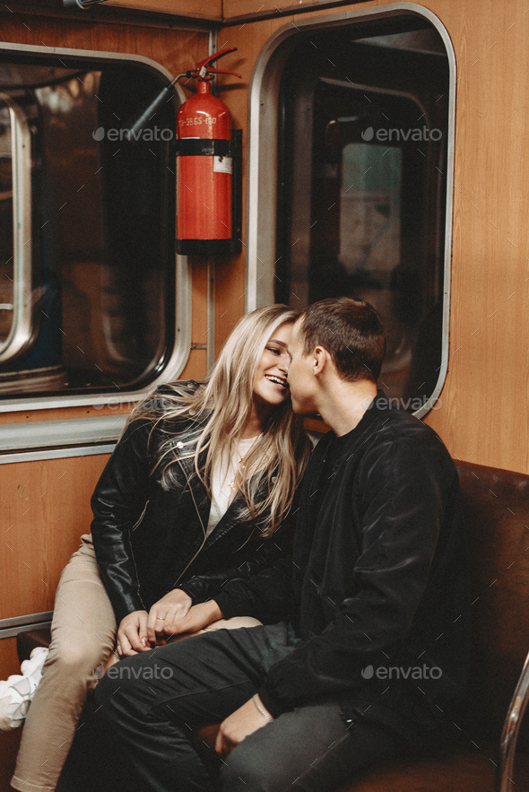 Cute happy couple siting and laughing in a subway Stock Photo by ...