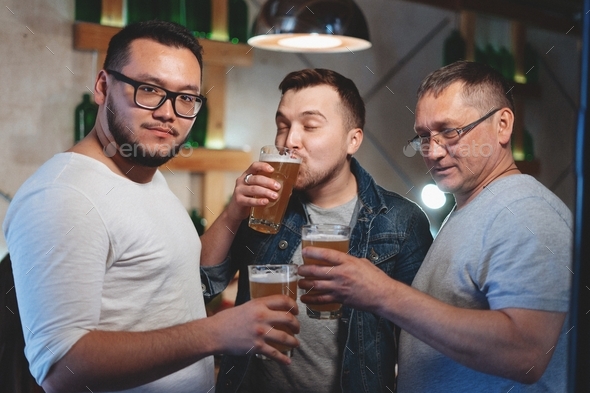 Three male friend different ages are drinking beer in a bar Stock Photo ...