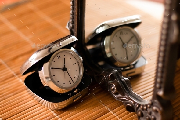 Pocket folding watch in the mirror. Time concept Stock Photo by masaniko
