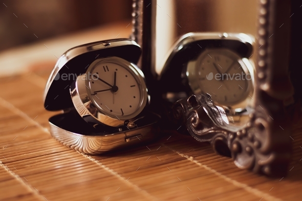Pocket folding watch in the mirror. Time concept Stock Photo by masaniko