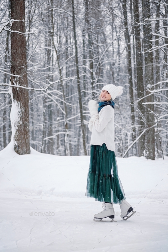 Ice skating in winter forest. Young caucasian woman walking on snowy ...
