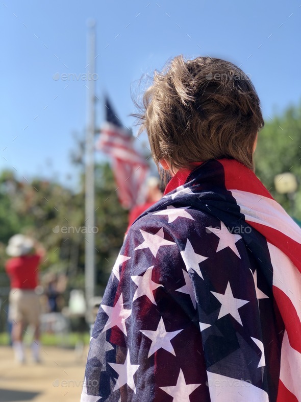 Child wearing flag at flag raising ceremony Stock Photo by reinasmyth