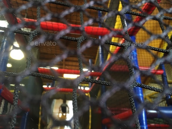 Netting of indoor playground single boy blurred in distance Stock Photo ...