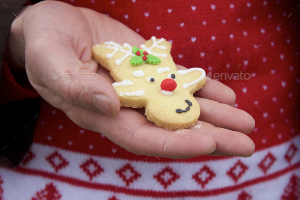 Man in festive Christmas jumper holding Decorated Christmas cookie ...