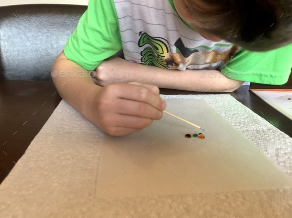 Boy doing science experiment water droplets on wax paper Stock Photo by ...