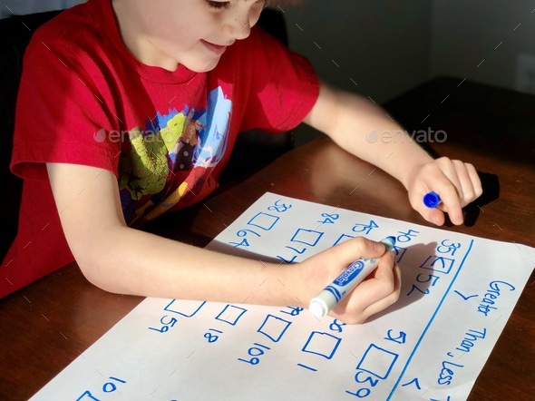 Kindergarten boy doing math work for homeschool Stock Photo by reinasmyth