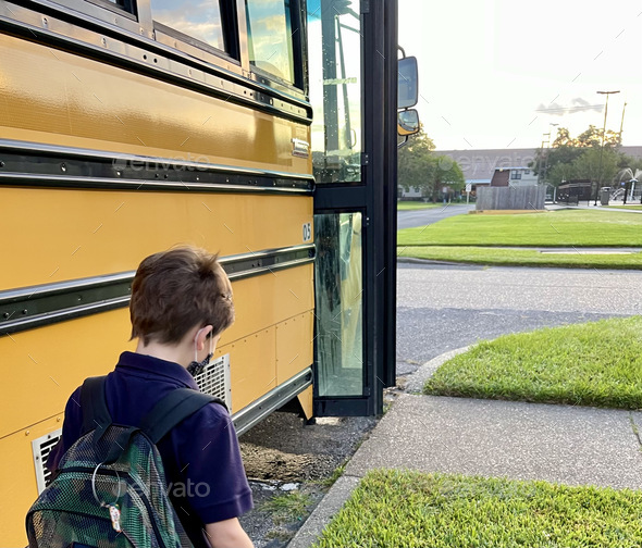 Boy walking up to school bus on first day of school Stock Photo by ...