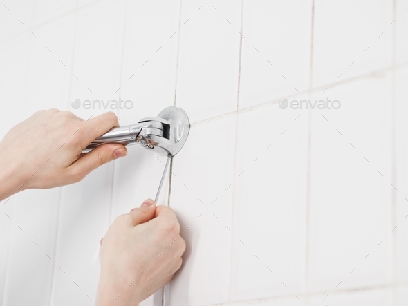 The hands of a caucasian guy unscrew the screw with a small hex wrench ...