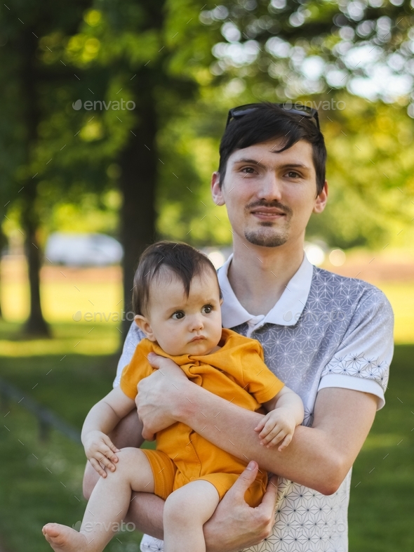 Caucasian handsome happy young dad holding in his arms his little ...