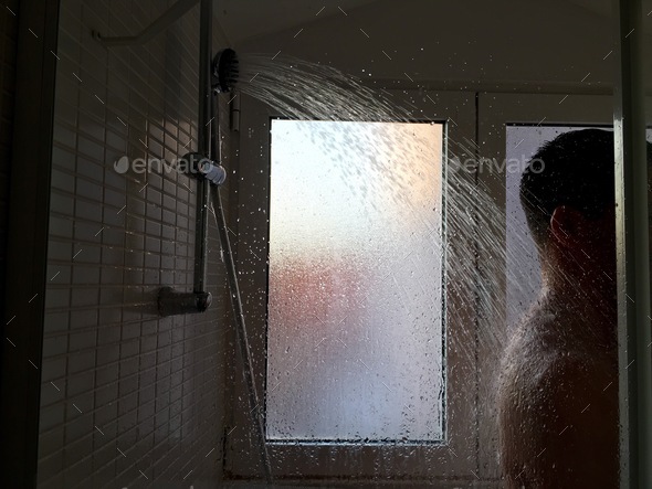 Man taking a shower with light shining through the window Stock Photo ...