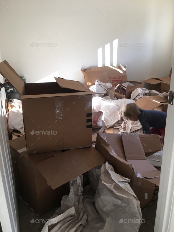 Moving boxes in a very messy room with toddler playing in there Stock ...