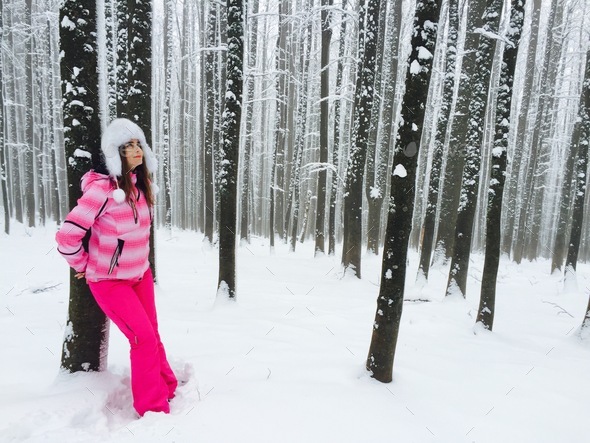 Woman in pink winter clothes in a forest of trees covered in snow Stock ...