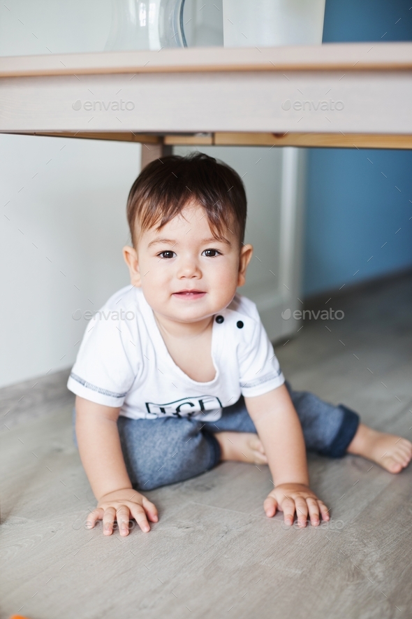 happy kid baby boy under table in new home, happy smiling baby moving ...