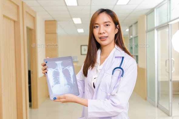 portrait of smart female doctor holding tablet to show X-Ray picture ...