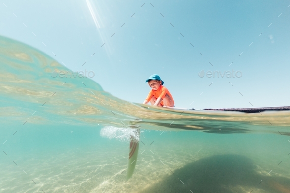 Little boy is sitting on a windsurfing board in the sea Stock Photo by ...