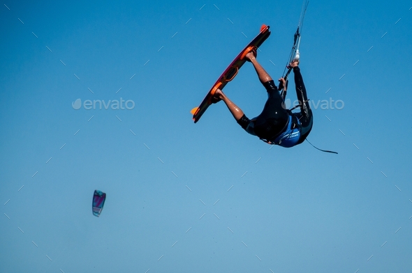 Kite surfing. A kiteboarder is flying on his board in the air ...