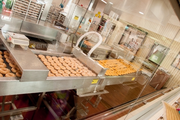 Donuts factory machine. Fresh made donuts frying and glazing Stock ...
