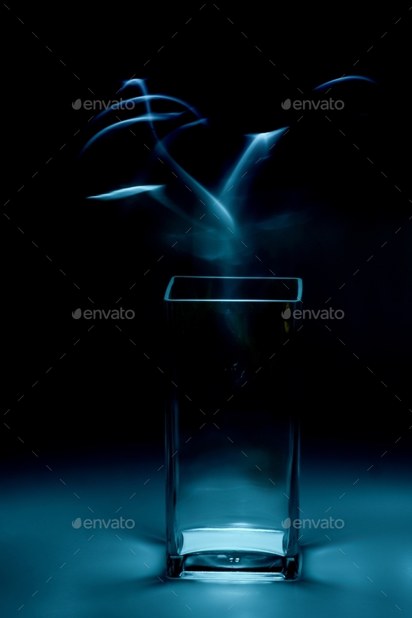 Mystical blue smoke above the rectangular glass vase. Concept of magic ...