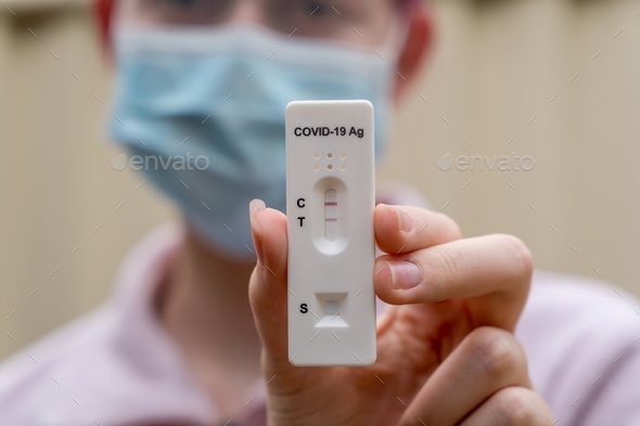 Gir wearing face mask with positive Covid-19 Rapid Antigen test result ...
