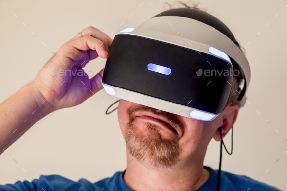 Sceptical bearded millennial man wearing VR headset. Virtual reality ...