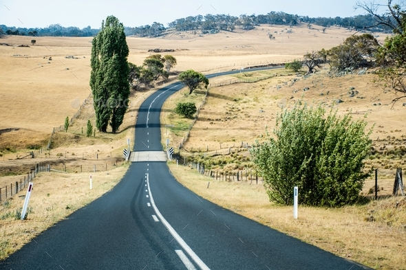 Open empty road surrounded by fields and farms. Causeway bridge Stock ...