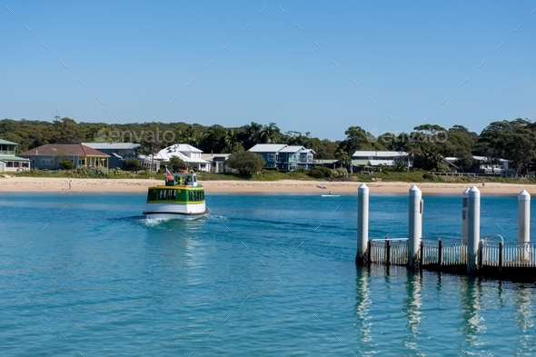 Sandy beach, the ocean and a jetty wharf. Boat ferry on the water Stock ...