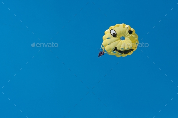 Parasailing. Yellow parachute with smiley face in a blue sky, Smile ...