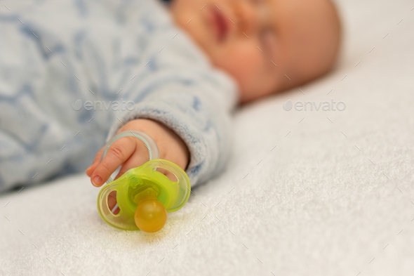 Cute little baby sleeping with pacifier dummy in his hand Stock Photo ...