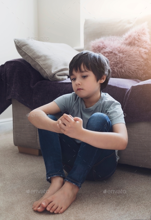 portrait Lonely kid sad face sitting on floor,child sitting alone next ...