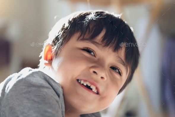 kid looking up with smiling face, child relaxing at home, boy having ...