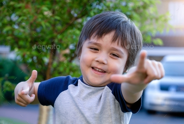 boy playing outside on spring, Active kid pointing fingers, Happy child ...