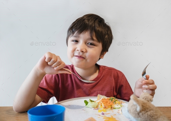 Boy eating vegetables salad for lunch or dinner, boy eating carrot ...