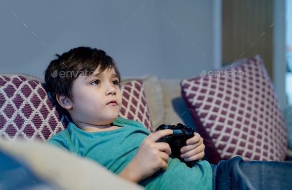 Happy kid holding video game or game console.Child having fun playing ...