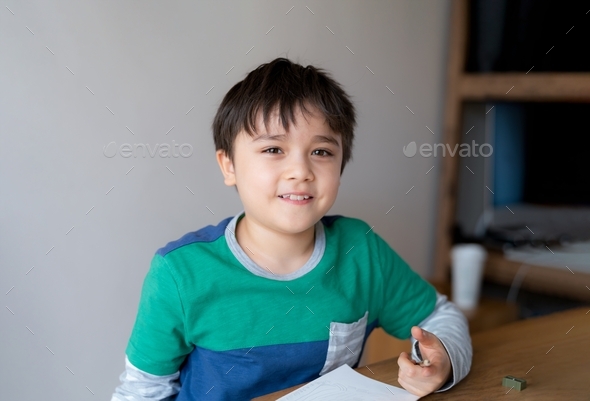 boy using pencil drawing or sketching on paper,Kid with smiling face ...