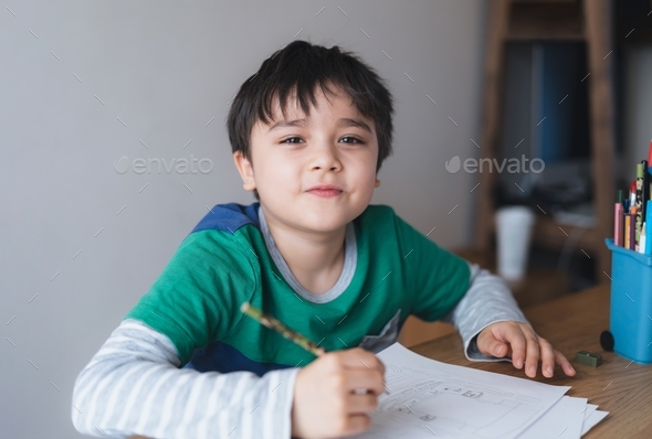Boy using pencil drawing, sketching on paper, Kid doing homework.Child ...