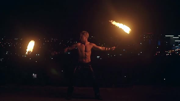 Young Blond Male Does Fire Dance with Two Torches, Spins Torches in the ...