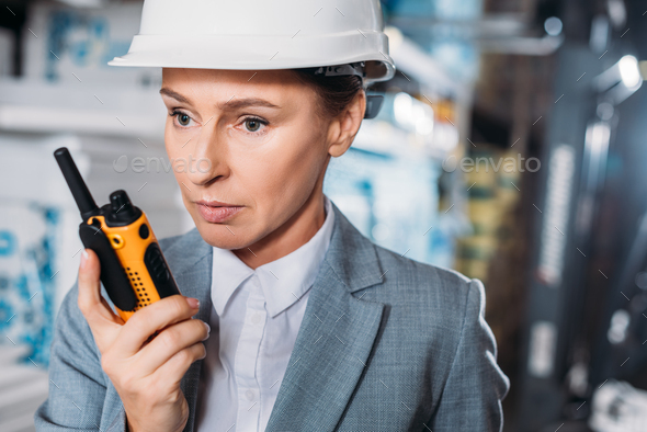 female inspector in helmet with walkie talkie in warehouse Stock Photo ...
