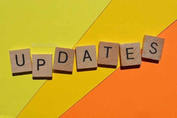 Updates, word in 3D wooden alphabet letters on yellow and orange ...