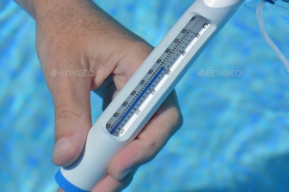 Summer vibes, woman checking the temperature of the swimming pool water ...