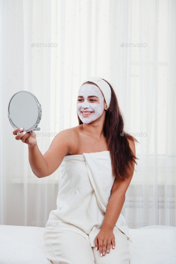 Smiling millenial woman look in mirror in beauty studio, white ...