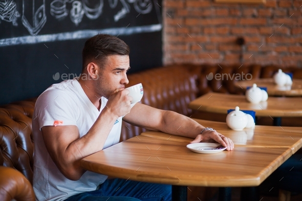 Handsome man drinking coffee in cafe. Stock Photo by olesyaklyots ...
