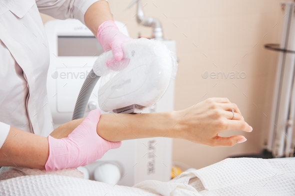 Young woman in beauty salon on arm laser hair epilation procedure Stock ...