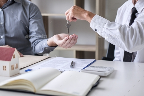 Real estate Sales manager giving keys to customer after signing rental ...