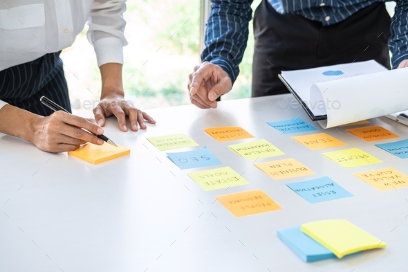 Two creative business people meeting and planning use post it notes ...