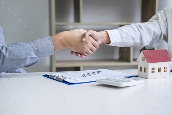 Real estate agent and customers shaking hands together celebrating ...