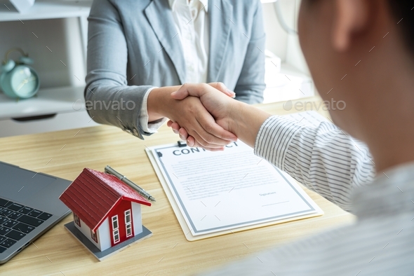 Estate agent and customers shaking hands together celebrating finished ...